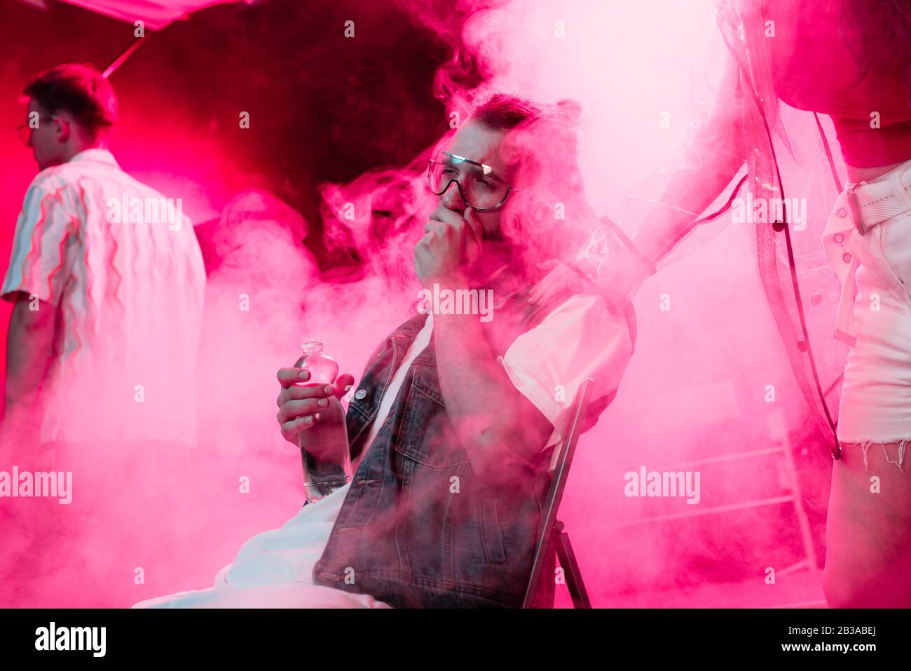 sick man sitting with bottle of water in nightclub Stock Photo - Alamy
