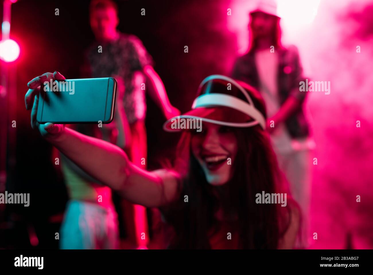 happy girl taking selfie on smartphone during rave party in nightclub ...
