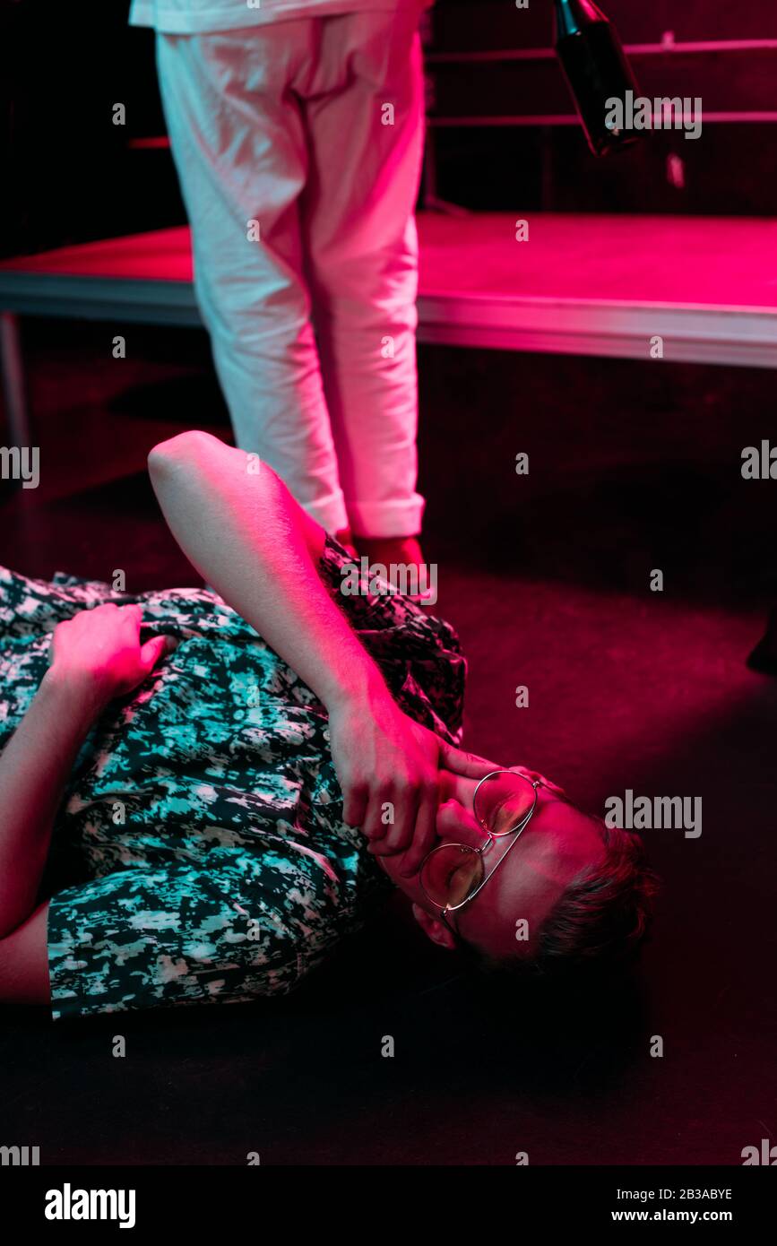 sick man lying on floor in nightclub and covering mouth with hand Stock ...