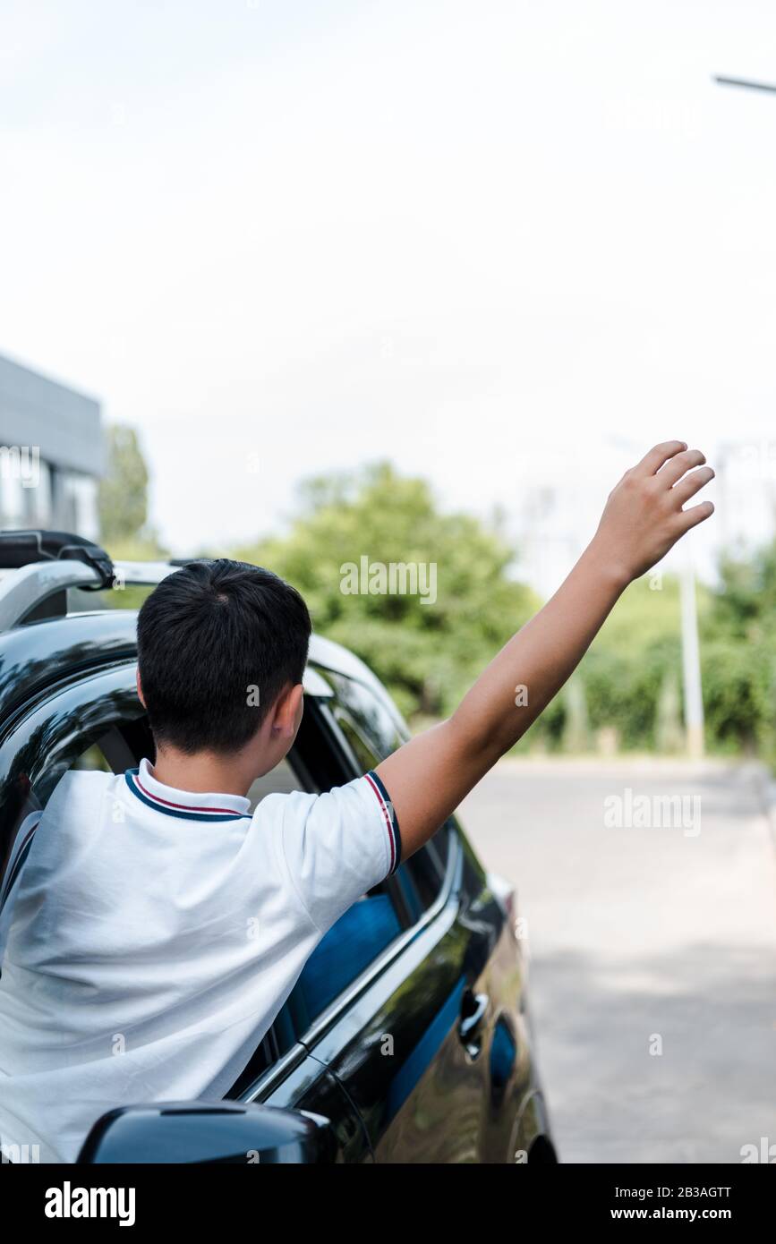back view of boy with outstretched hand in car window Stock Photo - Alamy