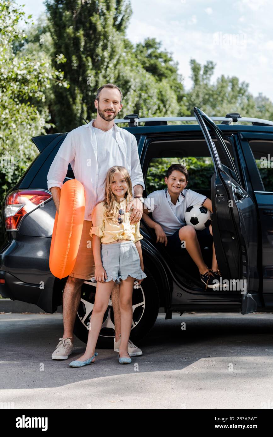 cheerful father and happy children standing near car Stock Photo - Alamy