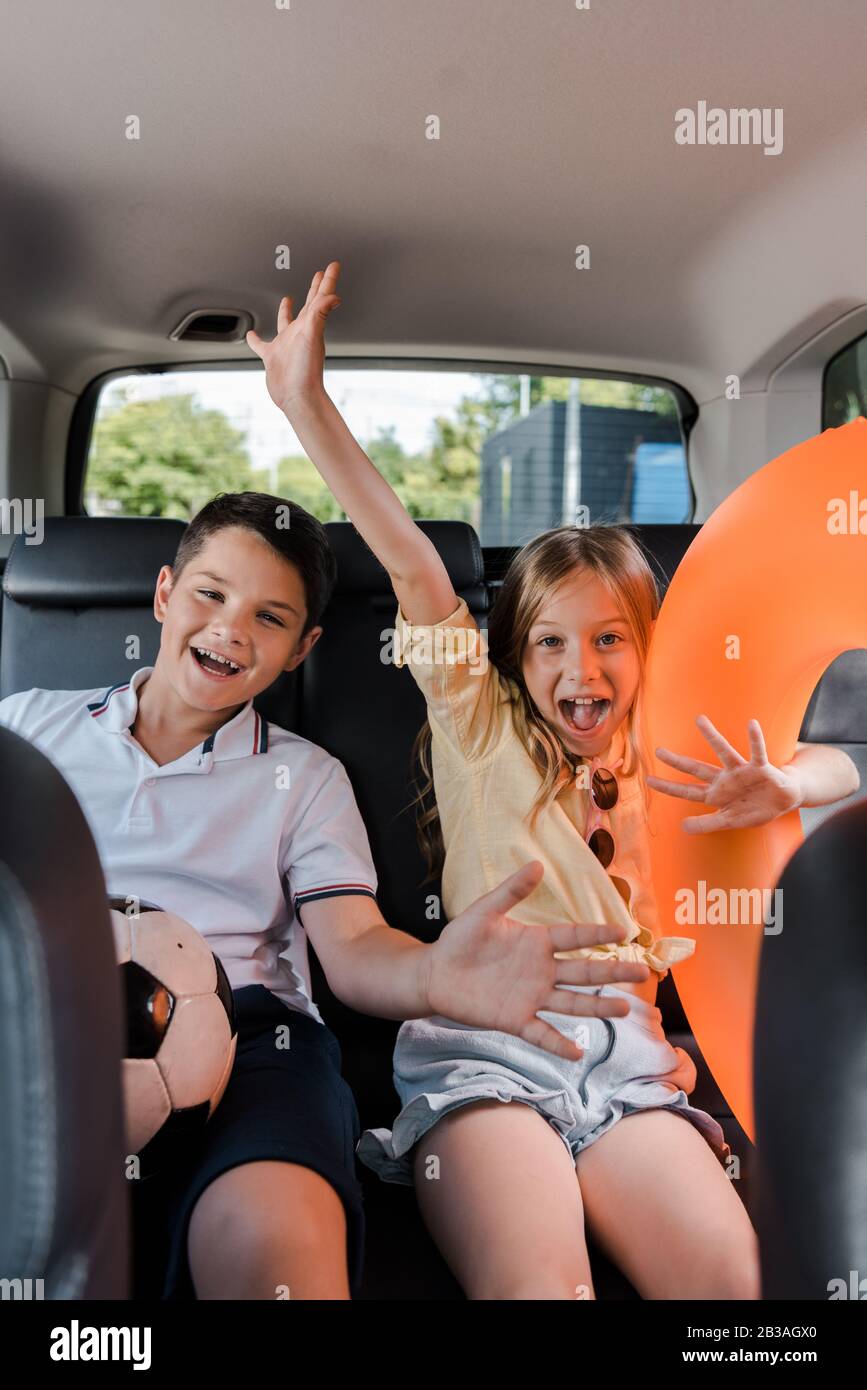 selective focus of cheerful sister and brother gesturing in car Stock ...