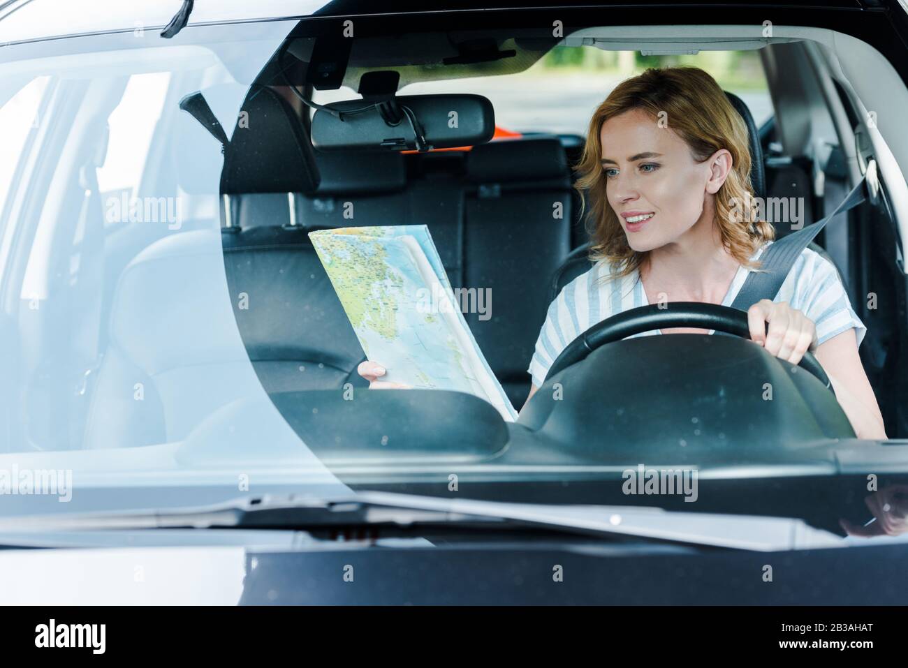 selective focus of woman looking at map and driving car Stock Photo - Alamy
