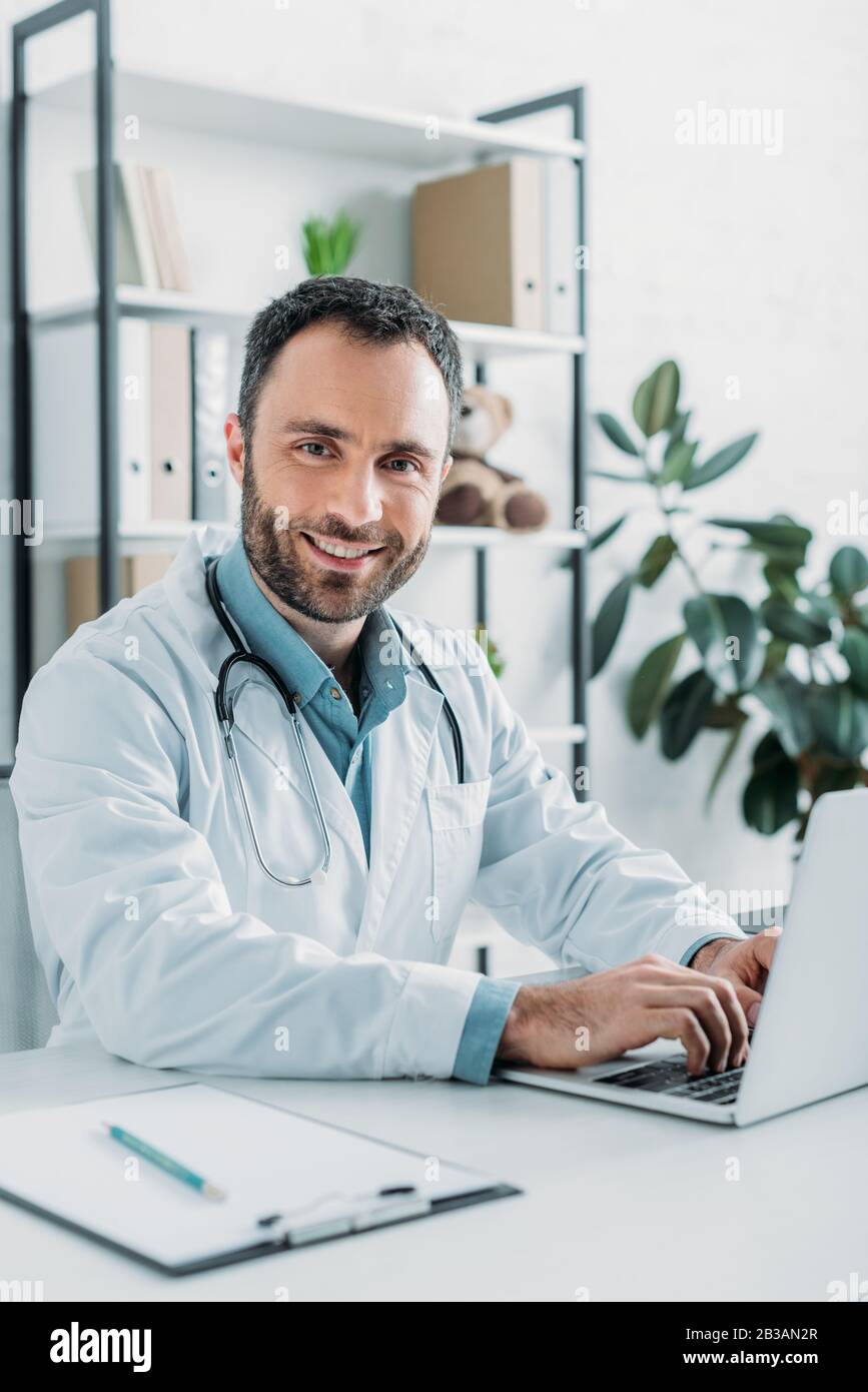 Doctor looking camera using laptop hi-res stock photography and images ...