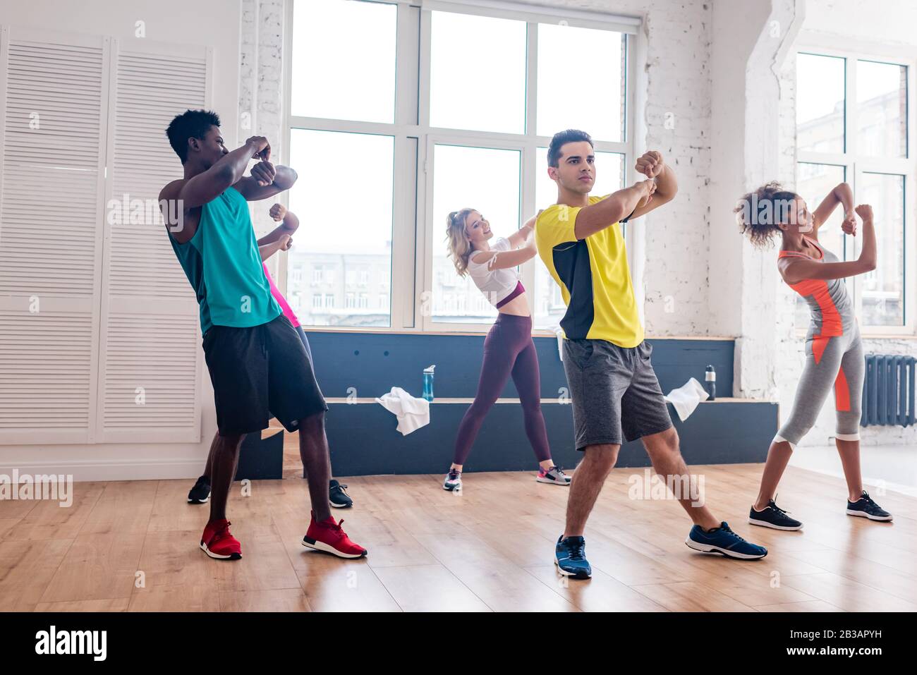 Young multicultural zumba dancers exercising movements in dance studio ...