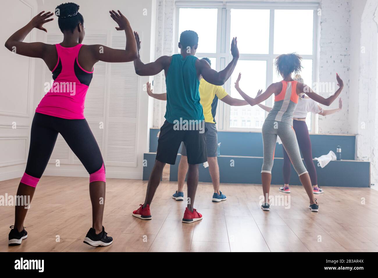 Back view of multicultural dancers performing zumba in dance studio ...