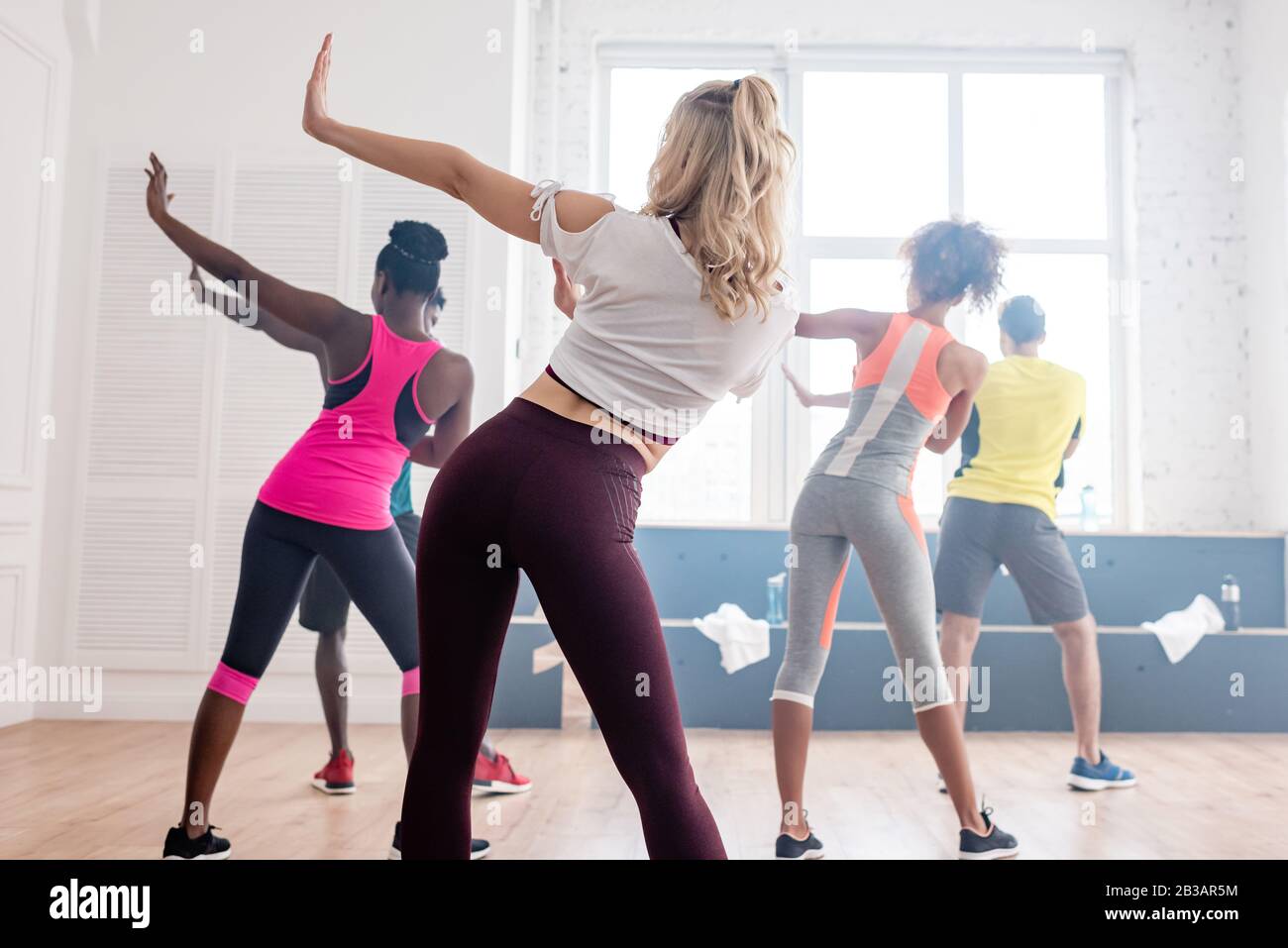 Back view of multiethnic zumba dancers performing movements in dance ...