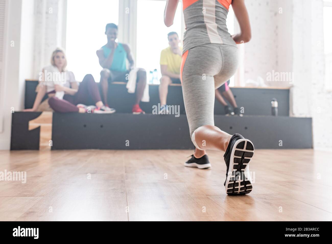 Selective focus of girl warming up with multicultural zumba dancers on ...