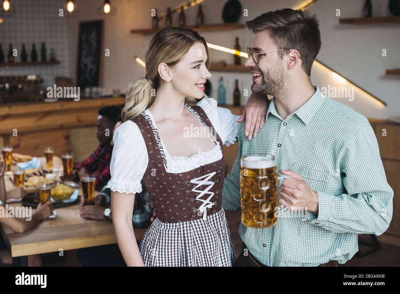 attractive waitress in german national costume standing near young man ...