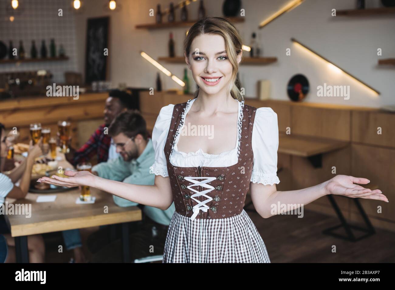 beautiful waitress in german national costume looking at camera and ...