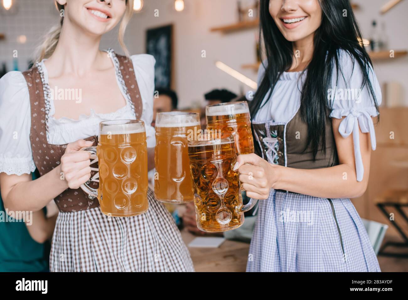 cropped view of two young waitresses in traditional german costumes ...