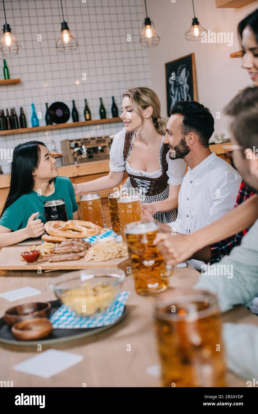 two waitresses in traditional german costume serving beer for ...
