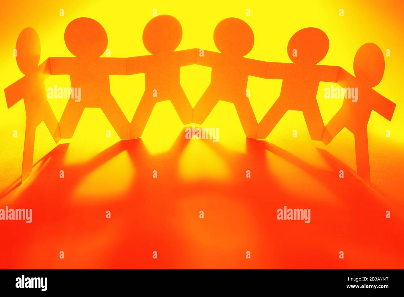 Paper chain team holding hands. Teamwork. Partnership Stock Photo - Alamy