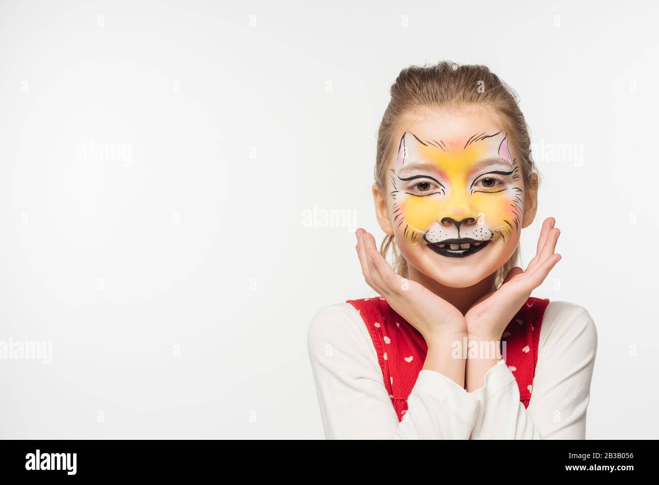 cute kid with tiger muzzle painting on face holding hands near face ...