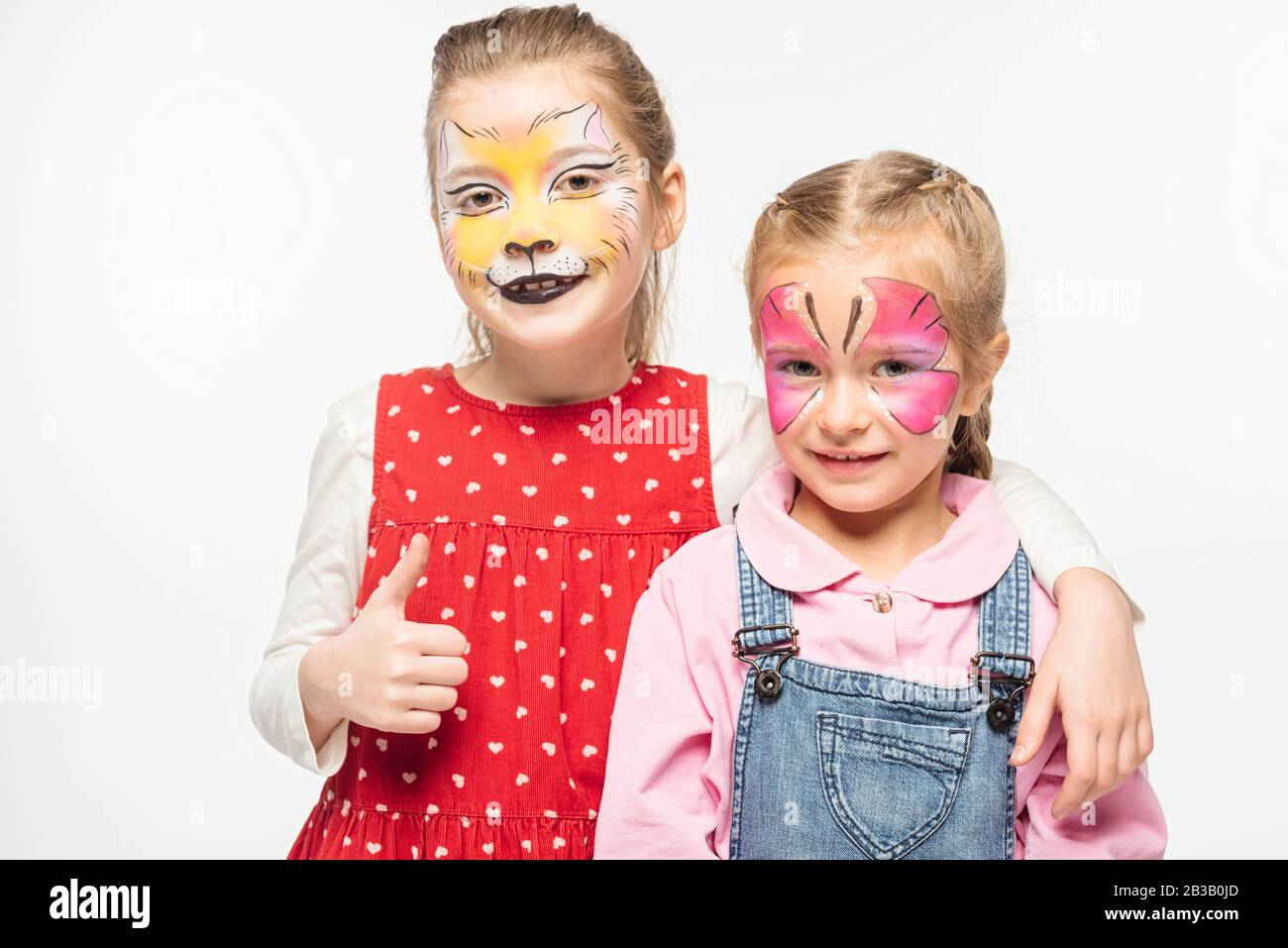 adorable kid with cat muzzle painting on face showing thumb up while ...