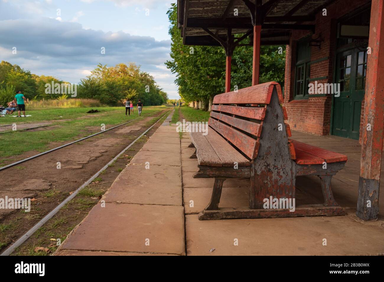 A wooden bench in an old abandoned train station with a view of the ...