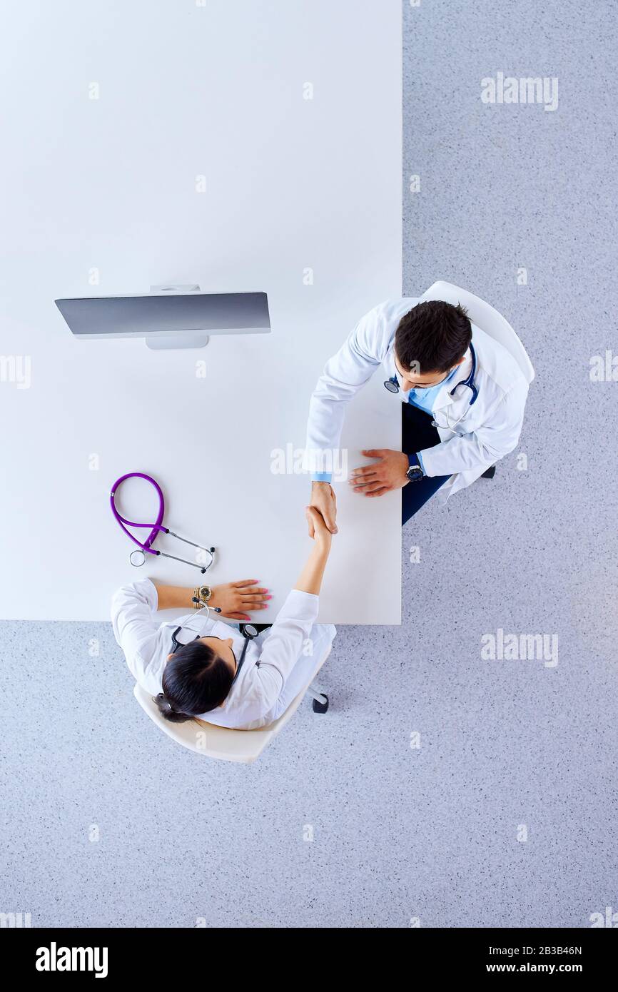 Professional muslim doctors handshaking at hospital. Flat lay, top view ...