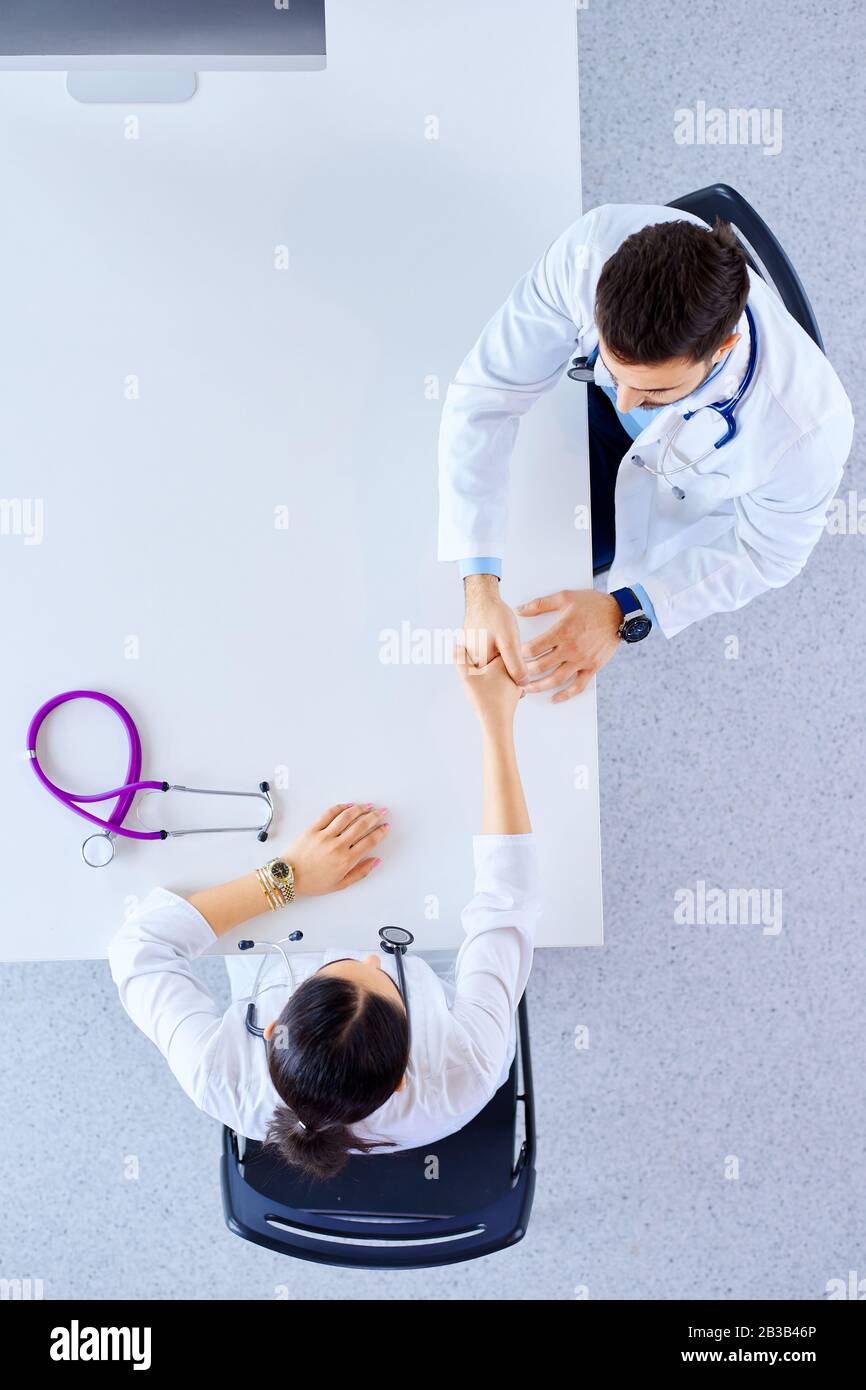 Professional doctors handshaking at hospital. Flat lay, top view. Group ...
