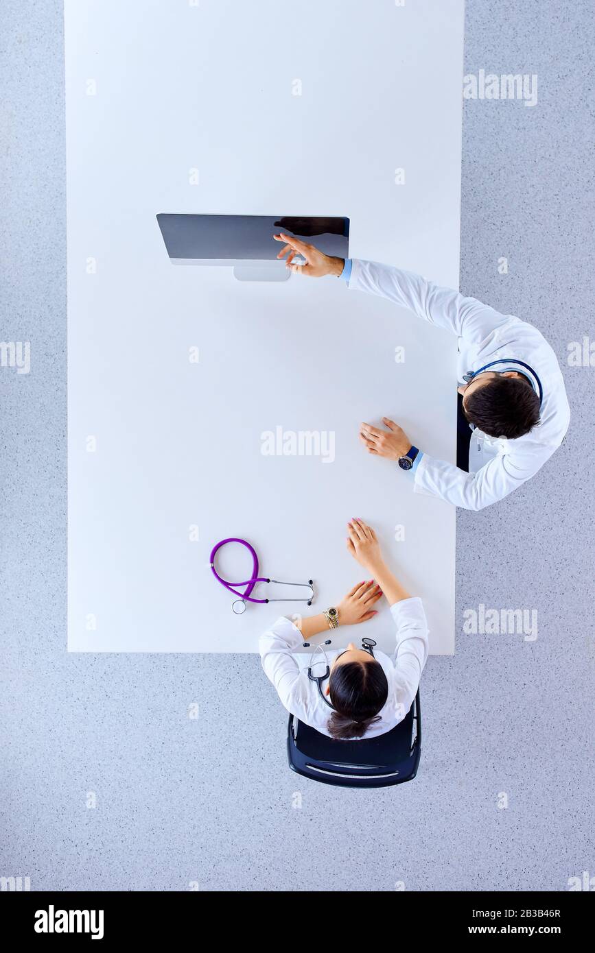 Doctors in the office talking and showing something on the monitor ...