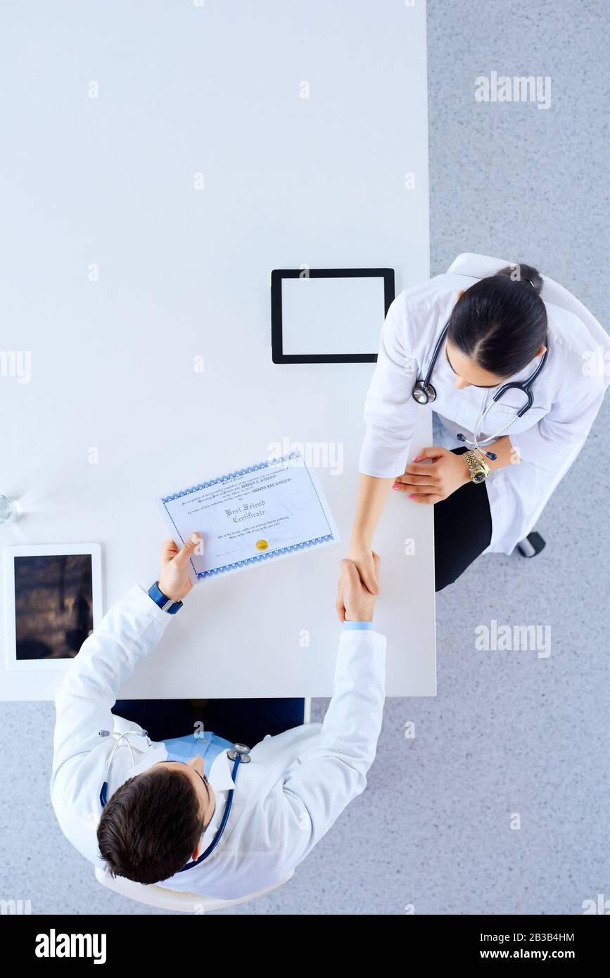 Top view, doctor gives a diploma and congratulates the intern, doctors ...
