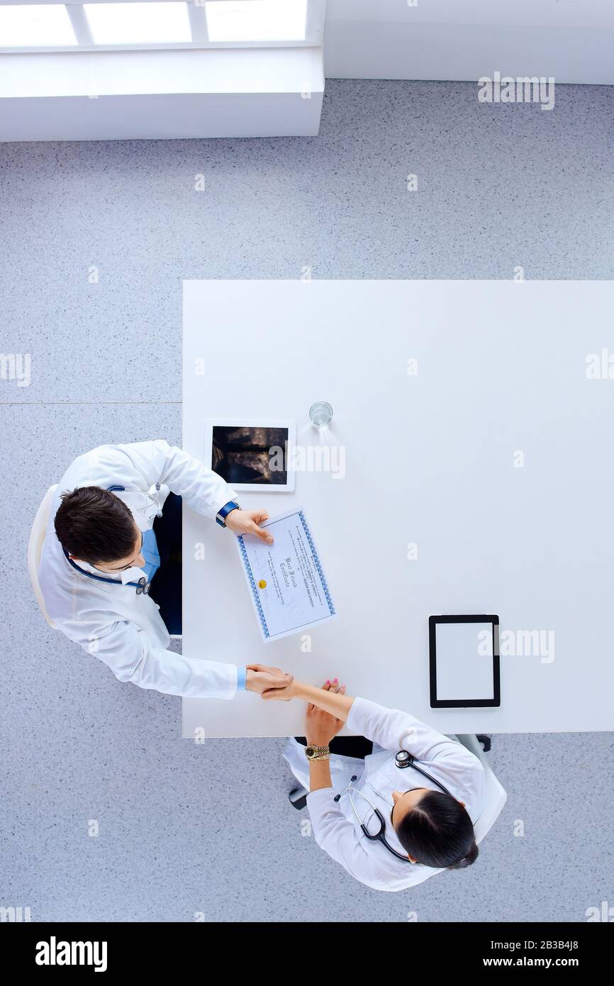 Top view, flat lay, two muslim doctors in the office handshaking ...