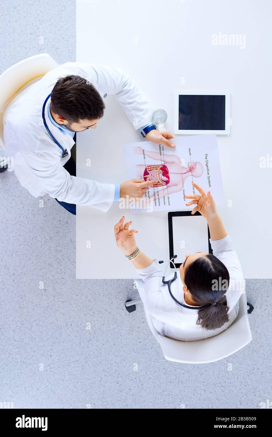 Medical team of doctors sitting and discussing in hospital at table ...