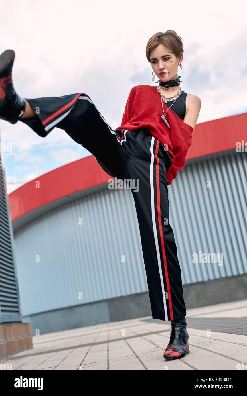 Urban Style. Young stylish woman standing leg up outdoors posing ...