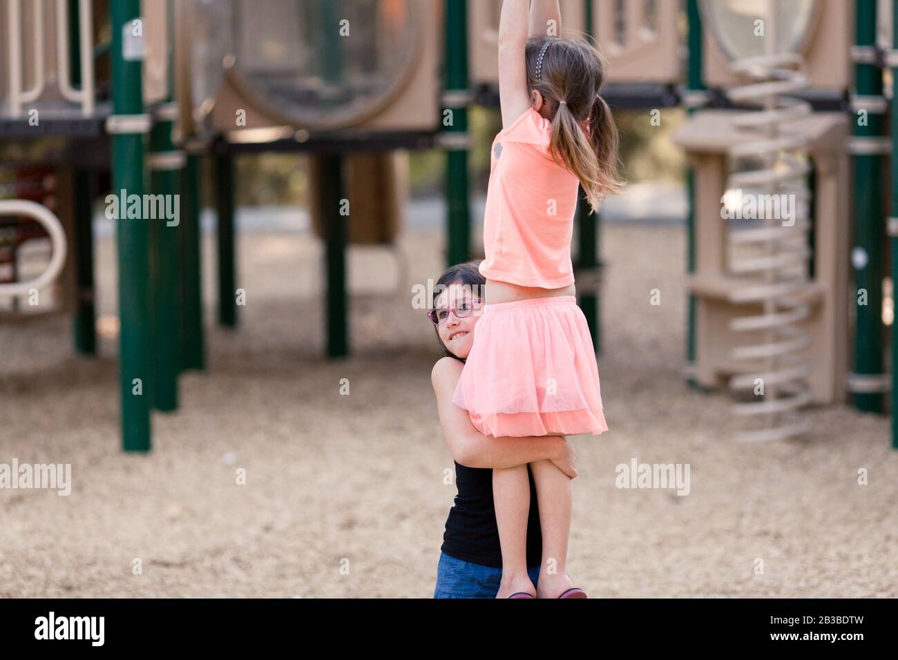 Sisters are playing and using teamwork on the playground Stock Photo ...