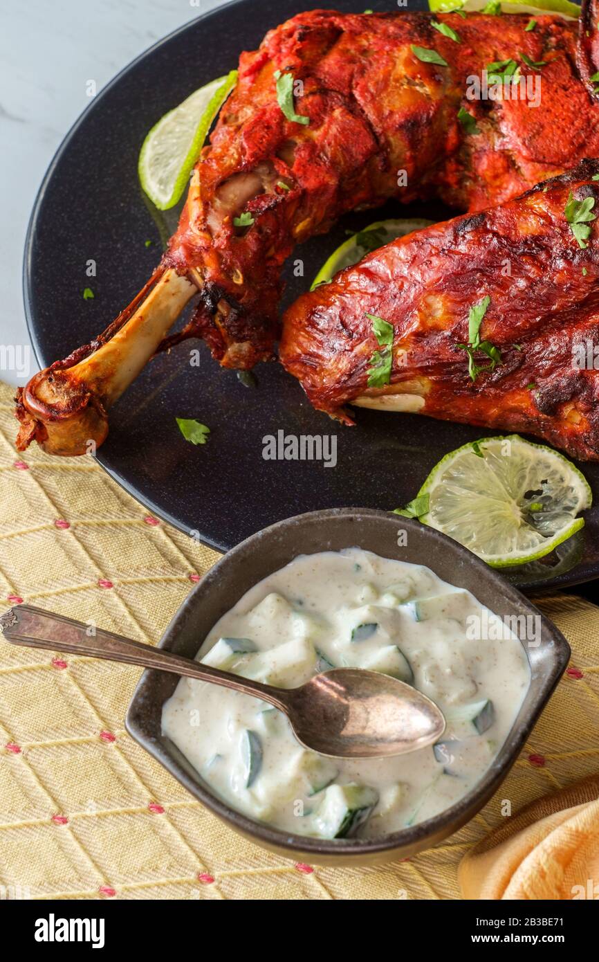 Indian cuisine spicy red Tandoori chicken with cucumber raita Stock ...