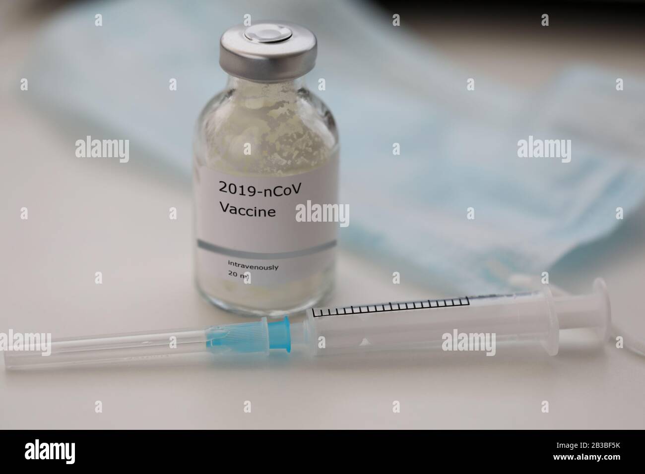 Vial with 2019-nCoV vaccine standing at table with empty syringe Stock ...
