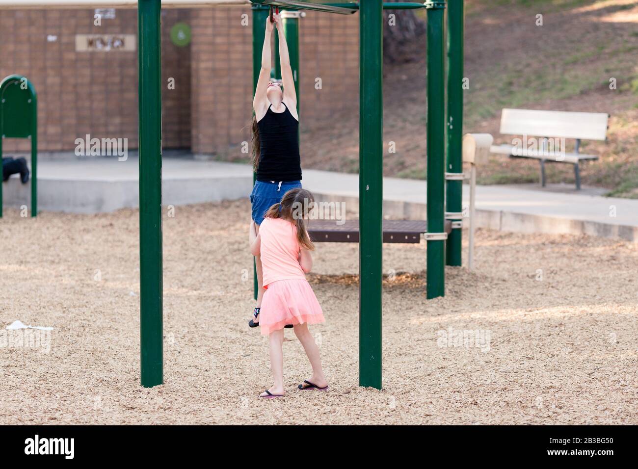 Sisters are playing and using teamwork on the playground Stock Photo ...