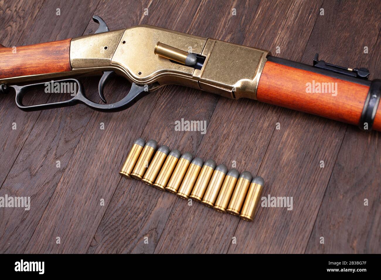 Wild west gun - lever-action repeating rifle with ammunition on wooden ...