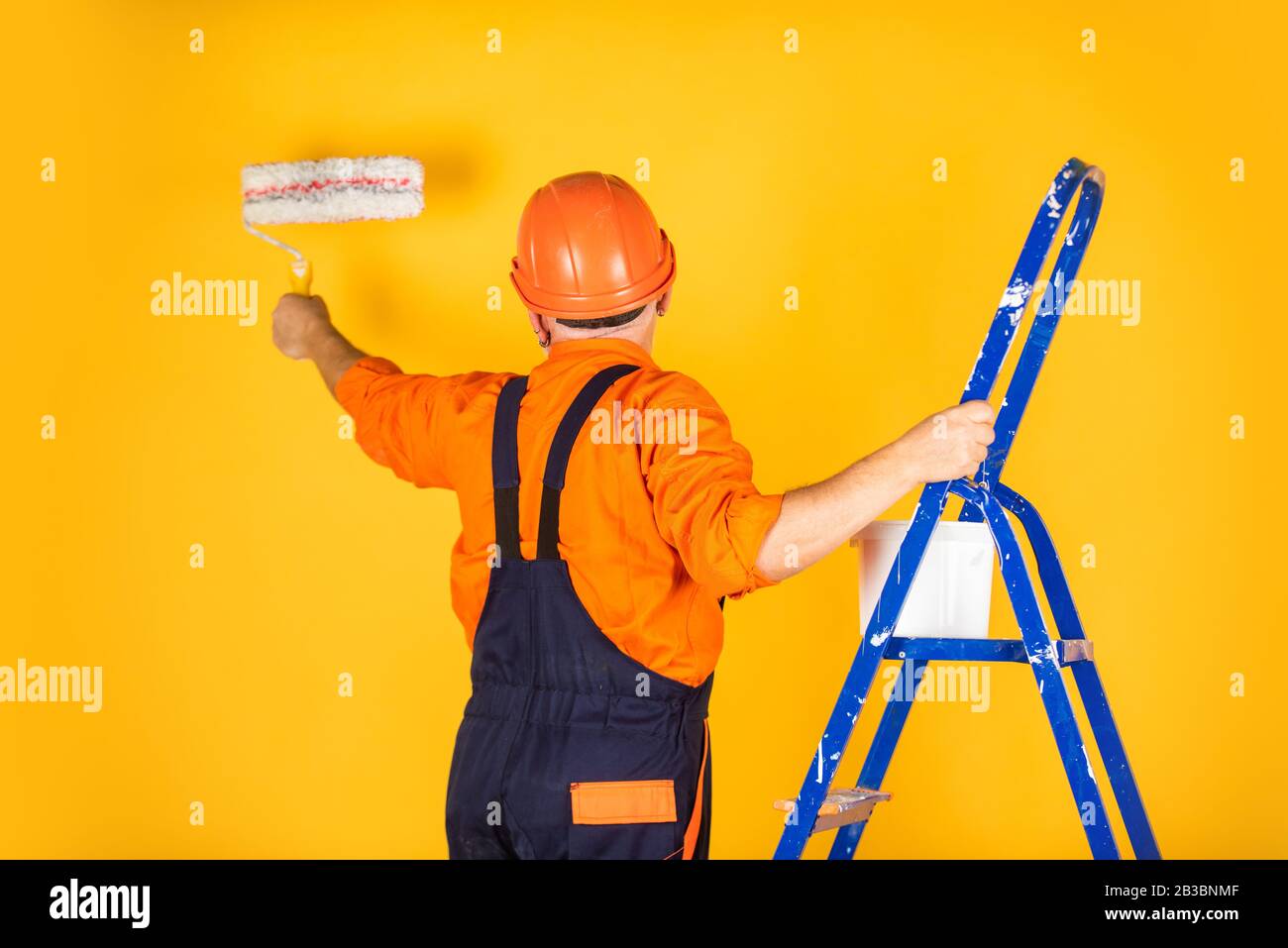 Foreman inspector. senior man painter use roller on ladder. painting ...