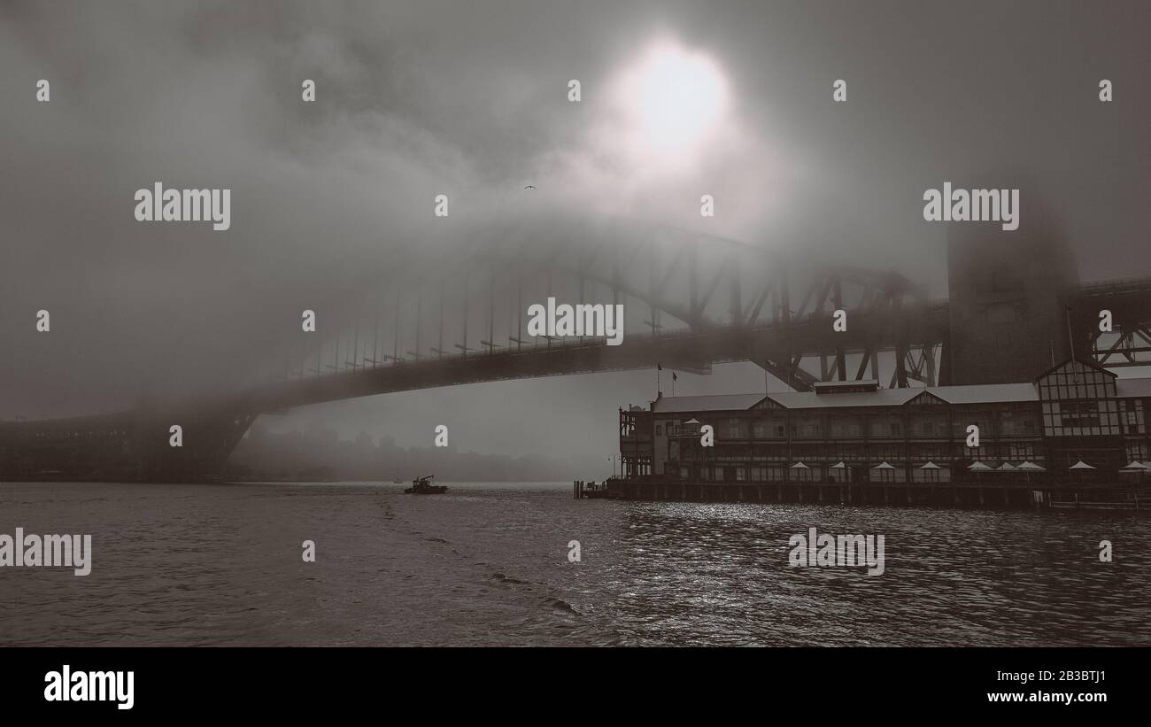 Early morning mist over Sydney Harbour Bridge as a solitary fishing ...