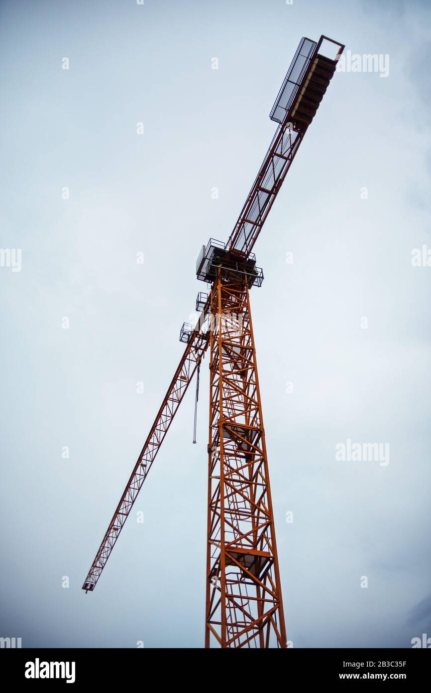 Bottom up view of a big tower crane against a cloudy sky. Background ...