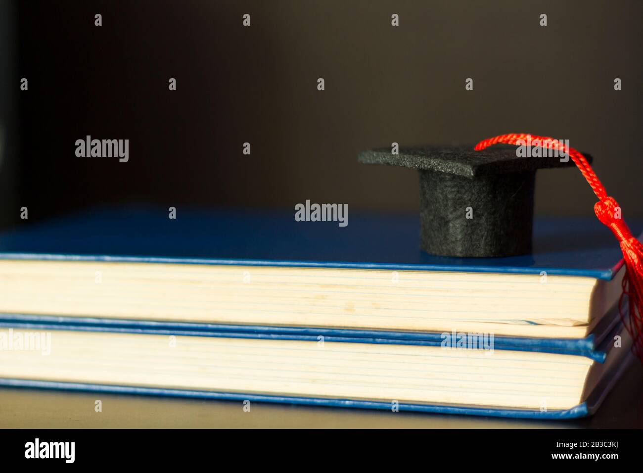 Graduation cap on top of books. Education and Graduation concept Stock ...