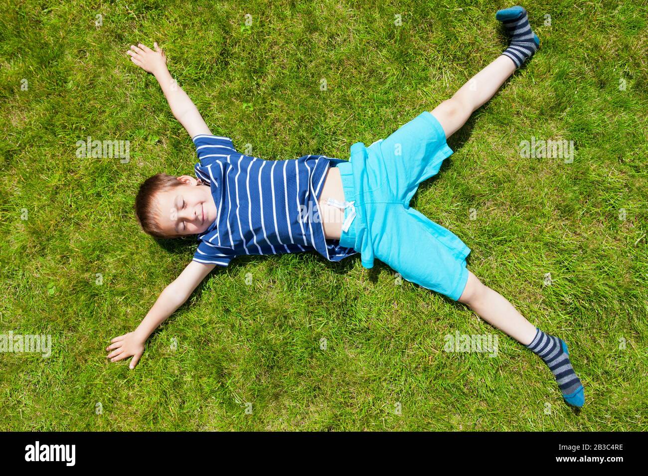 Boy lying on the grass Stock Photo - Alamy