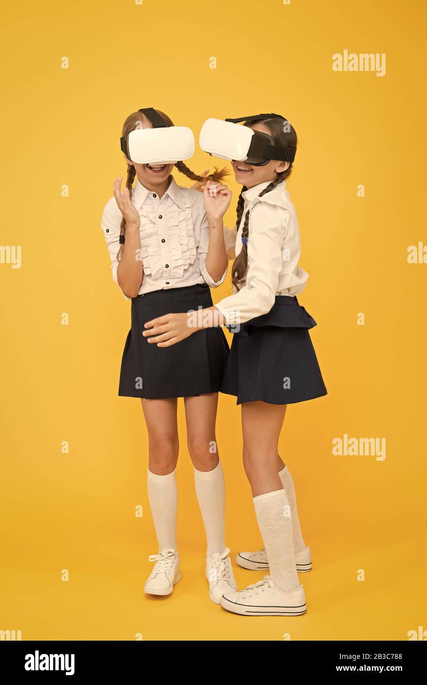 Children schoolgirls wear wireless VR glasses. Exploring augmented ...