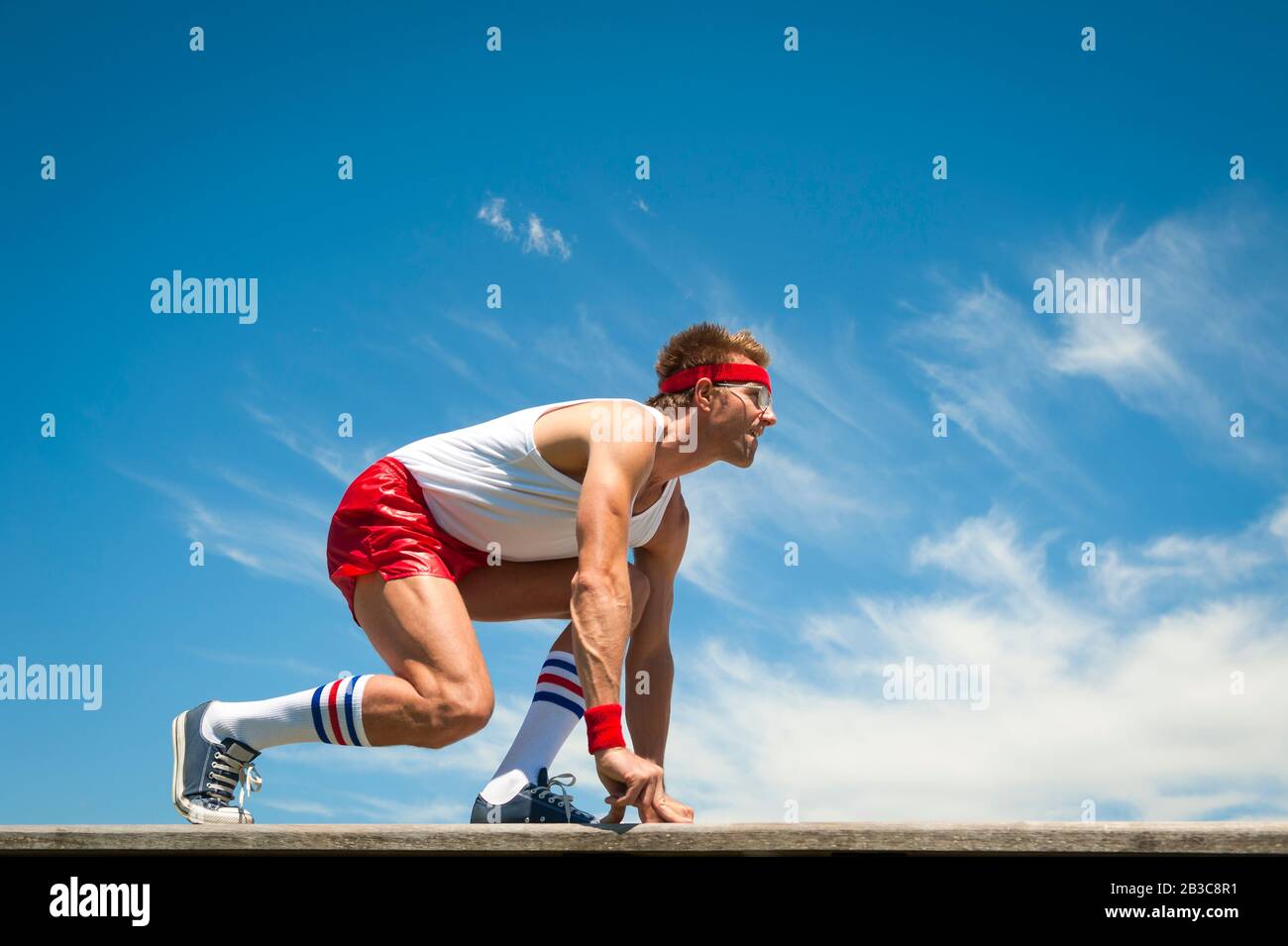 Nerd athlete crouching getting ready at the starting blocks to start a ...