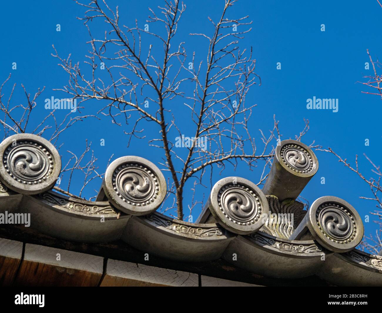 Traditional Japanese peaked roofs with Imperial Chrysanthemum symbols ...