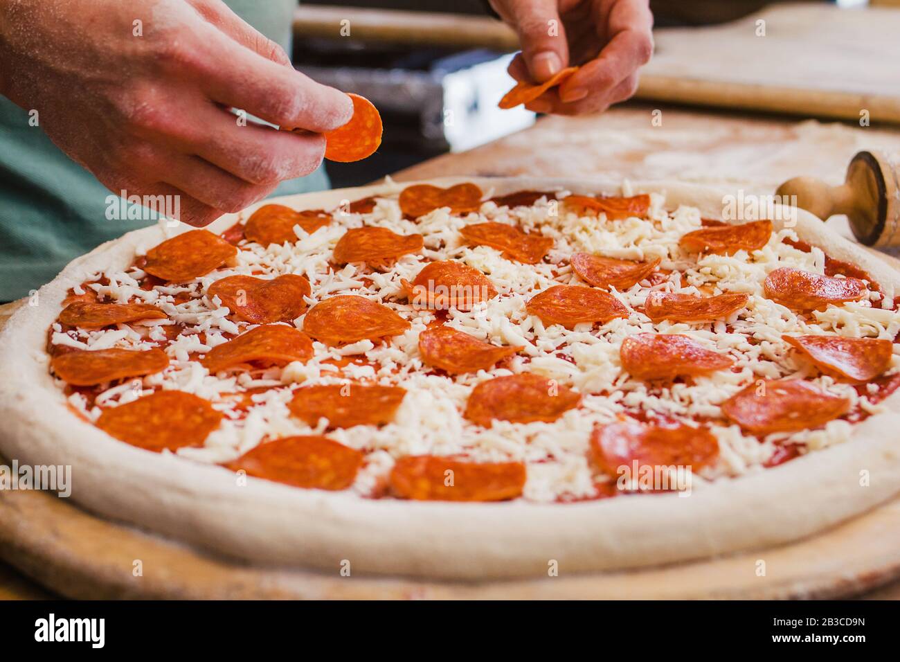 Hands preparing a pizza or making a Homemade Pepperoni Pizza Stock ...