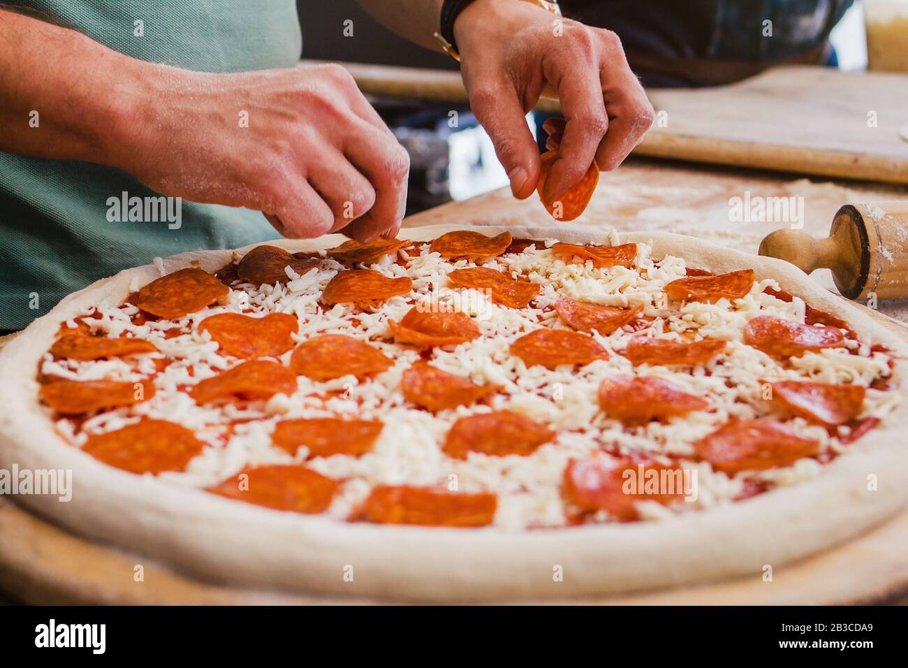 Hands preparing a pizza or making a Homemade Pepperoni Pizza Stock ...