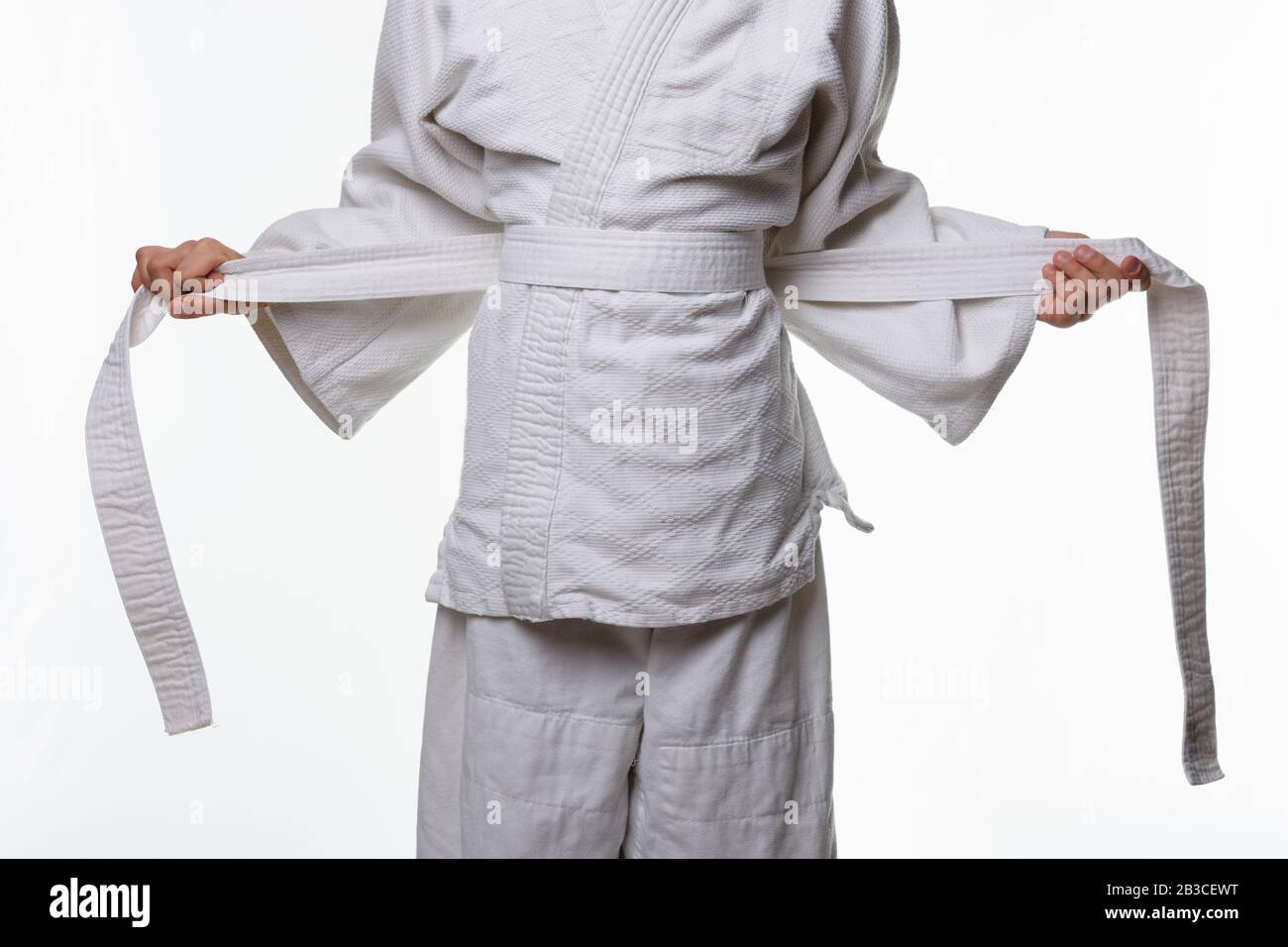 Stages of correct tying of the belt by a teenager on a sports kimono, step four Stock Photo - Alamy