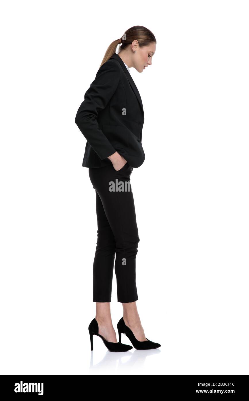 side view of a cute businesswoman wearing black suit waiting in line ...