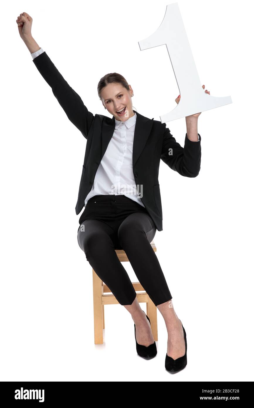 cute businesswoman wearing black suit sitting and holding number one ...