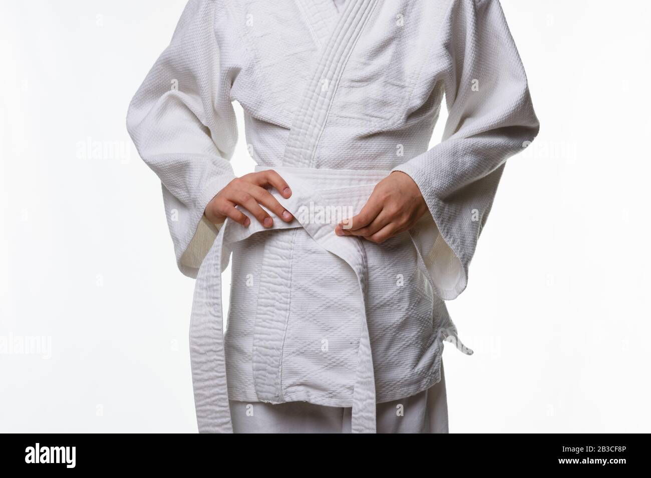 Stages of correct tying of the belt by a teenager on a sports kimono ...