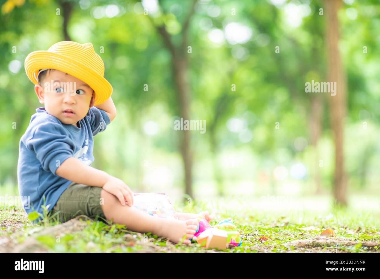 Kid boy with yellow hat travel in green city park toddler boy in nature ...