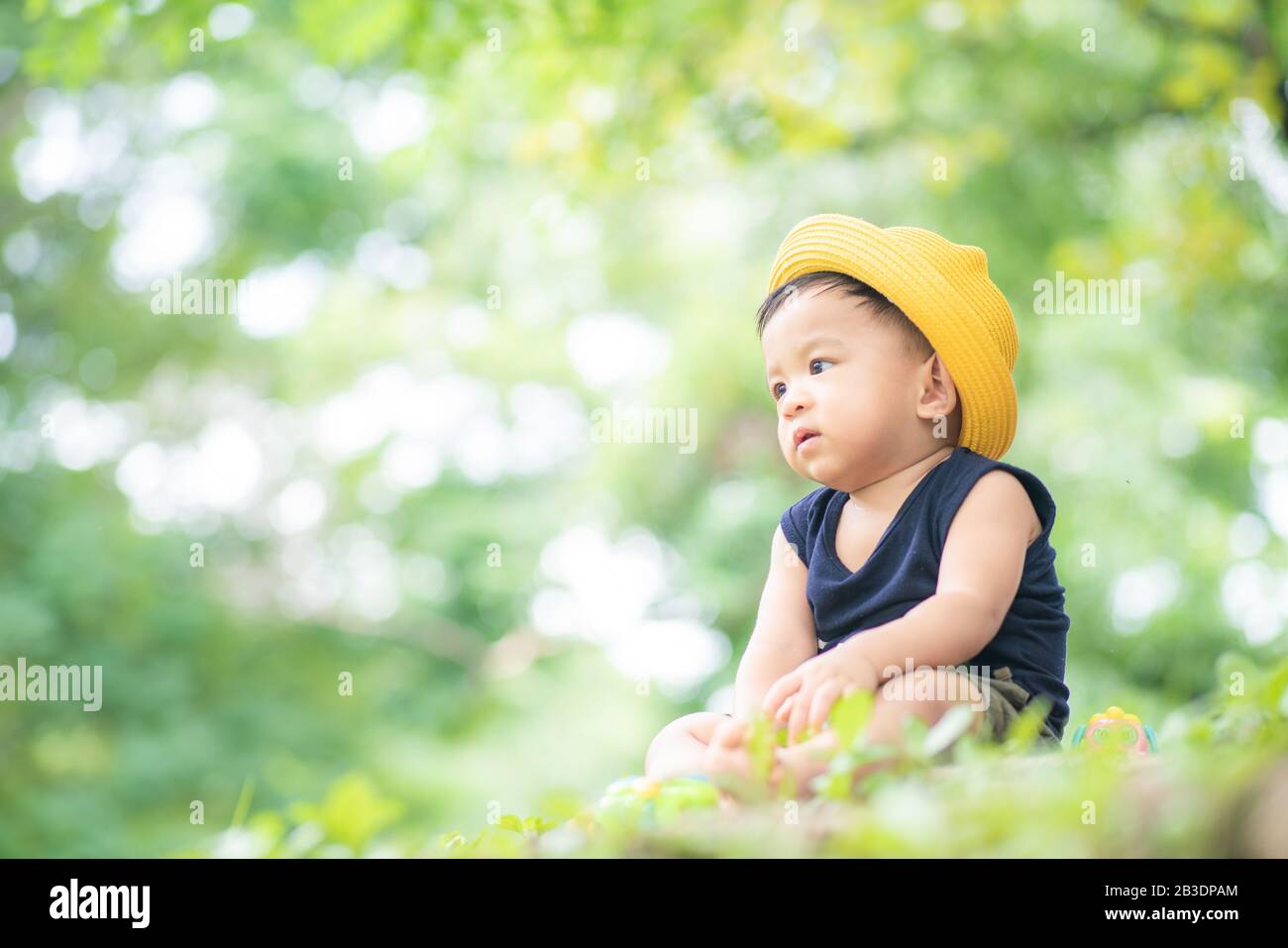 Kid boy with yellow hat travel in green city park toddler boy in nature ...