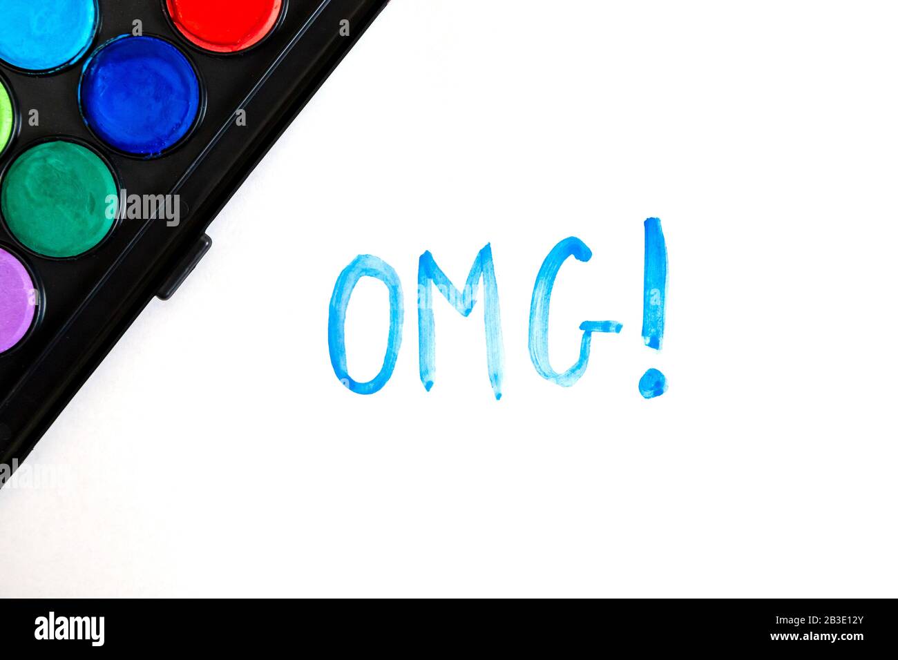 Handwritten OMG text with brush and watercolor paints on white ...