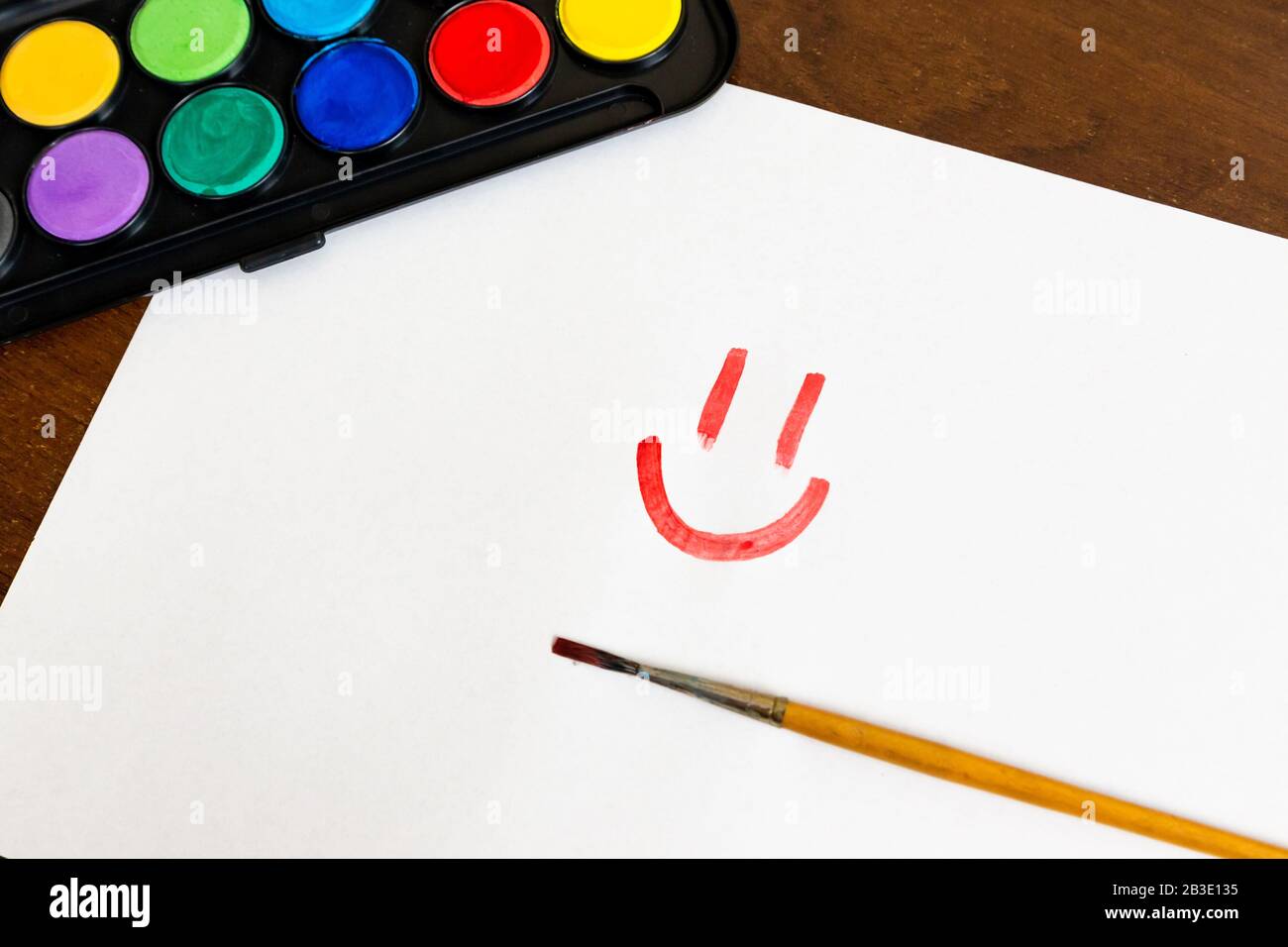 Smile face painted with brush and watercolor paints on white background ...